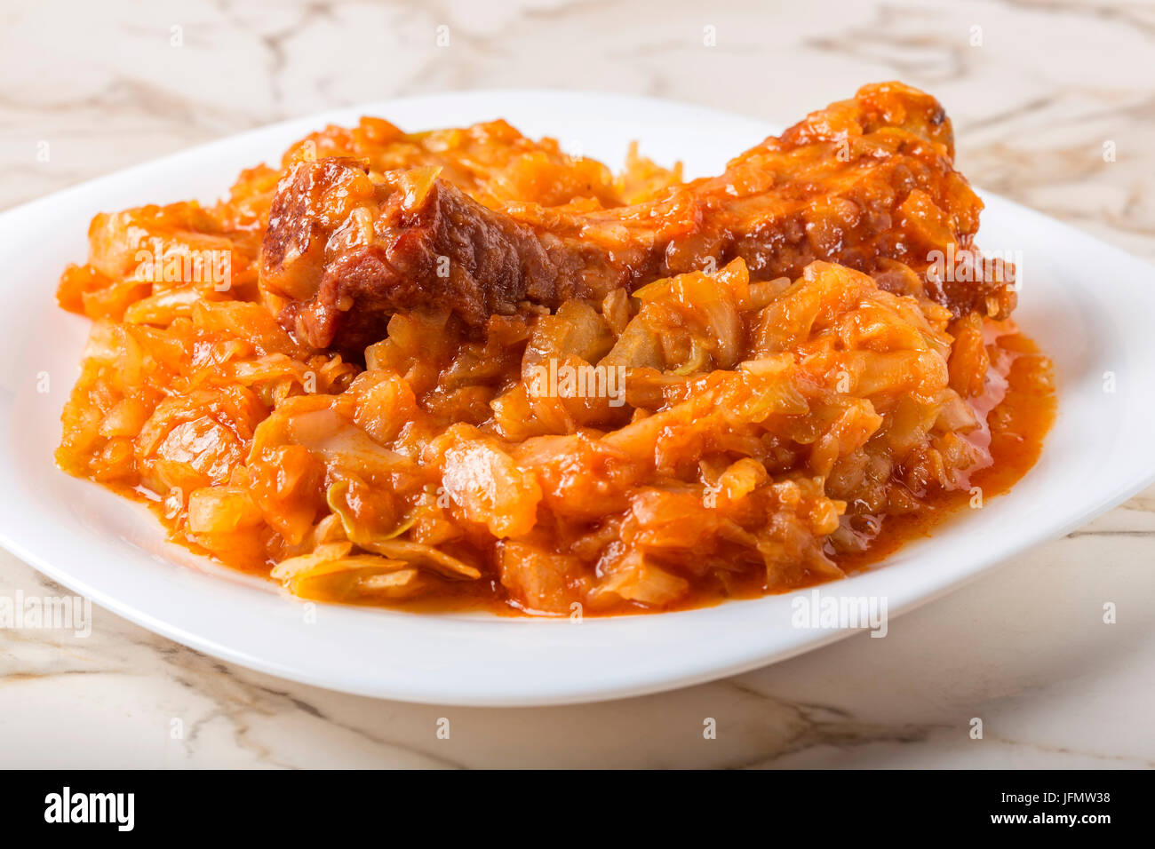 Cabbage cooked with Smoked Pork Ribs Served in white plate Stock Photo ...