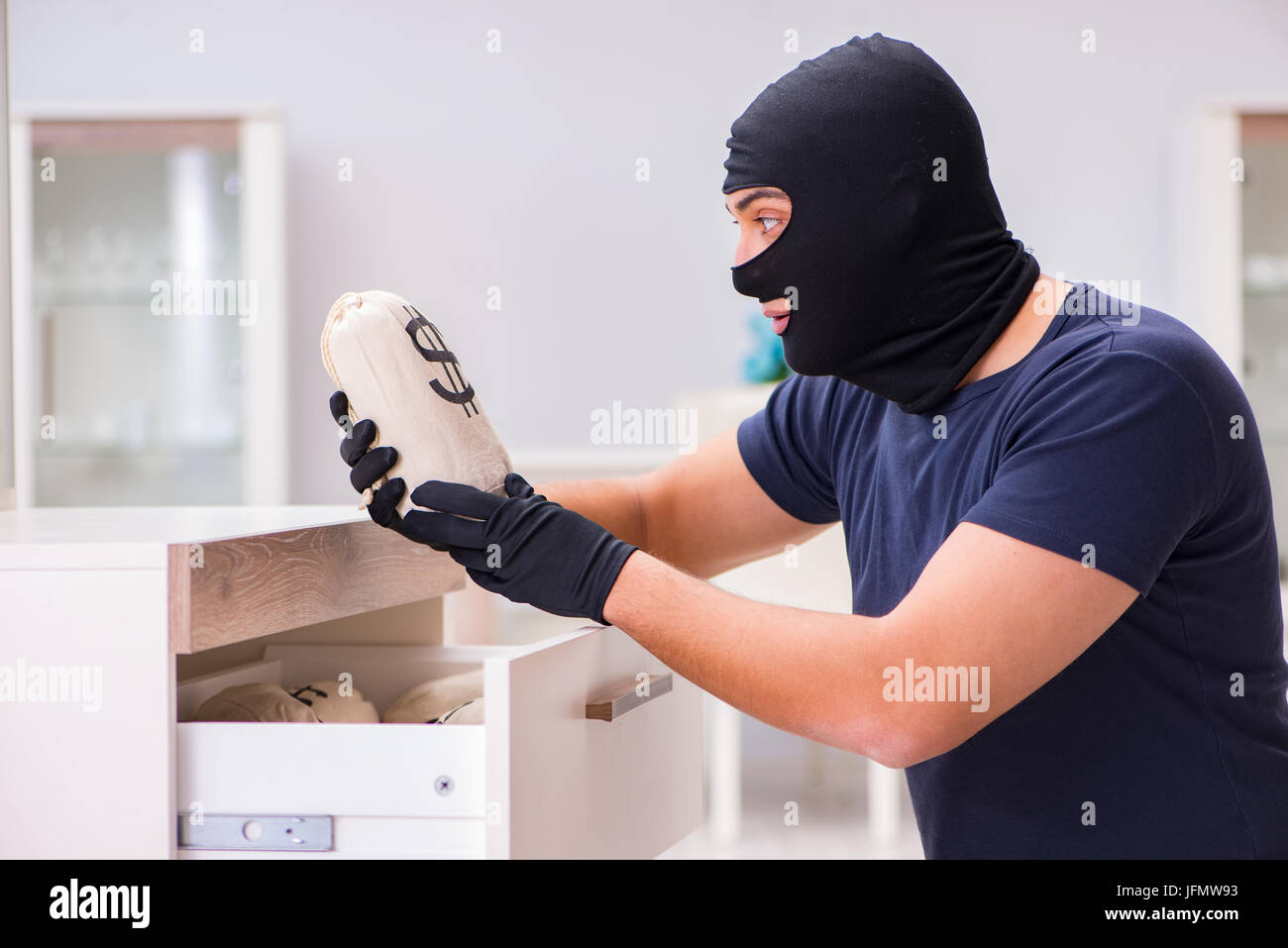 Robber wearing balaclava stealing valuable things Stock Photo - Alamy