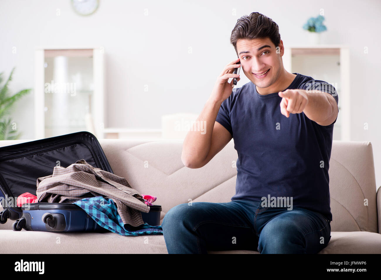 Man going on vacation packing his suitcase Stock Photo - Alamy