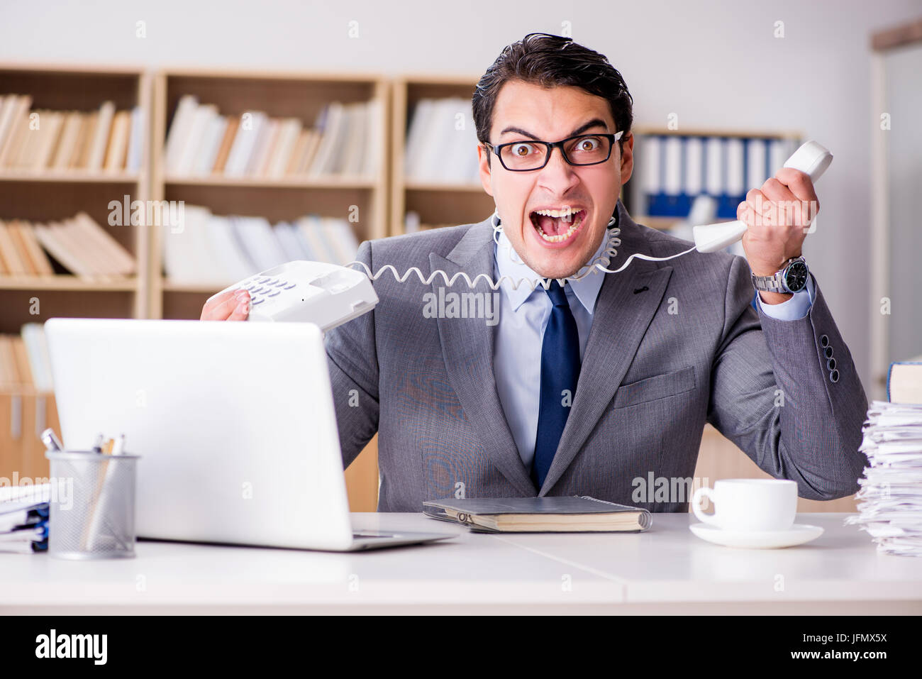 Angry businessman with too much work in office Stock Photo - Alamy