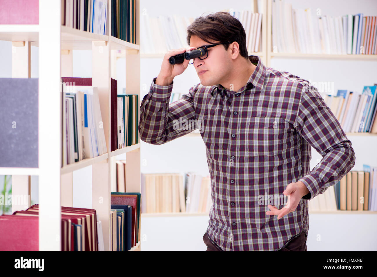 Young student looking for books in college library Stock Photo - Alamy