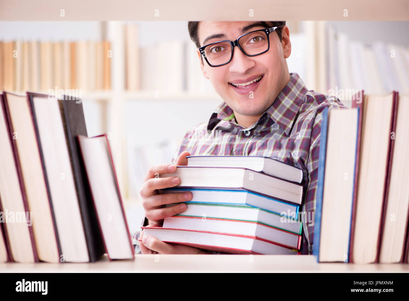 Young student looking for books in college library Stock Photo - Alamy