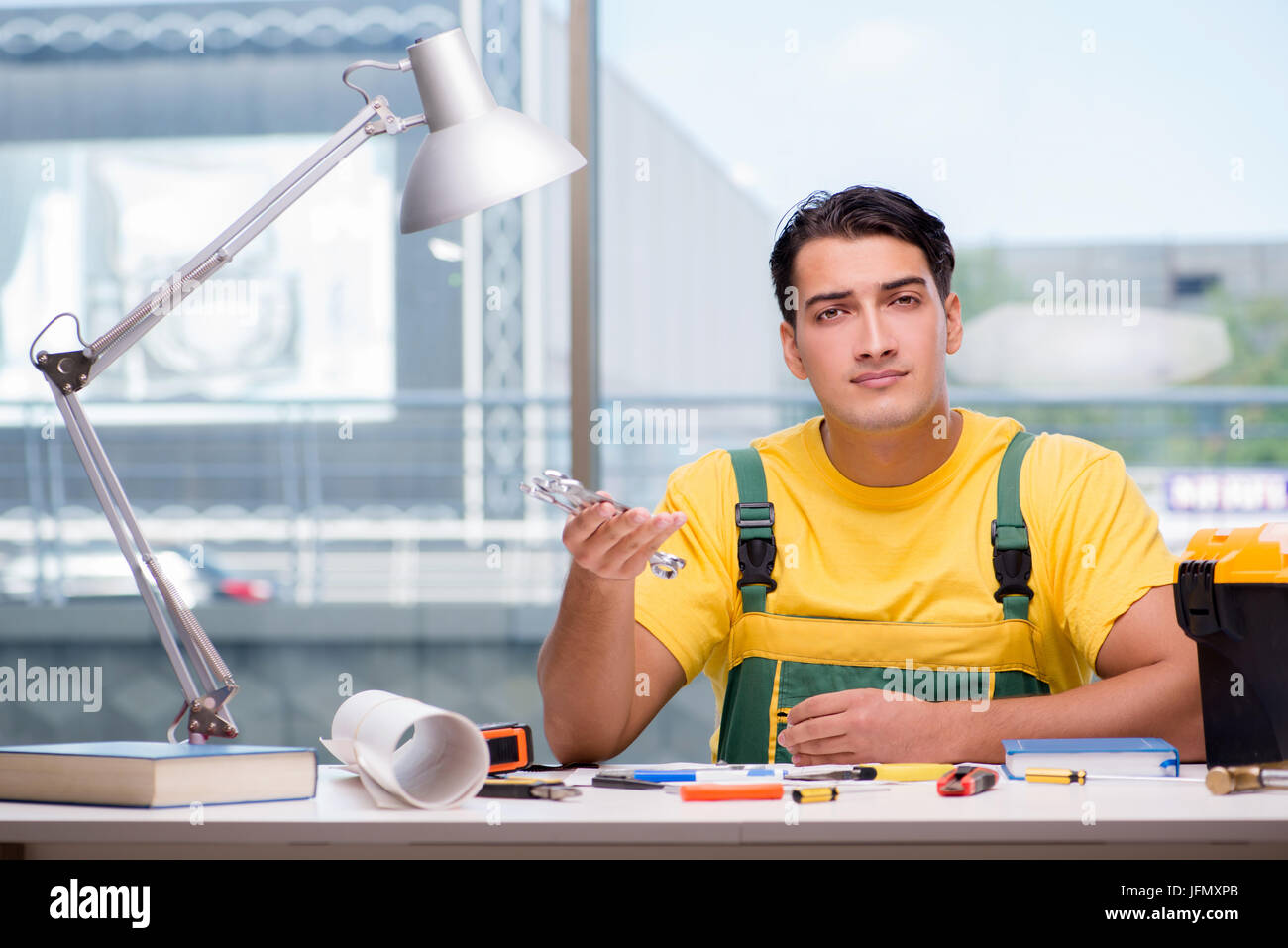 Construction worker sitting at the desk Stock Photo - Alamy
