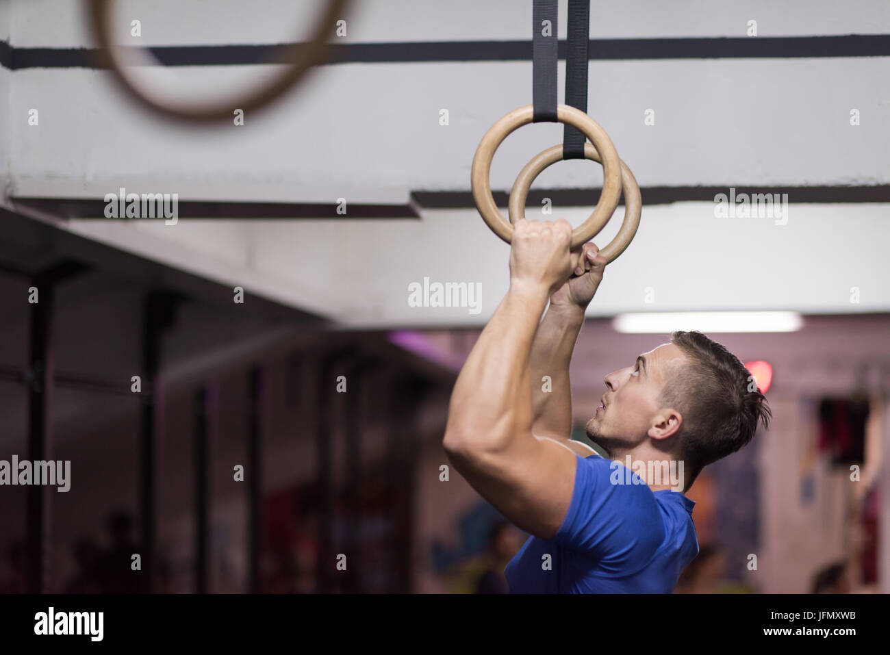 Fitness handsome man doing dipping exercise using rings in the gym ...
