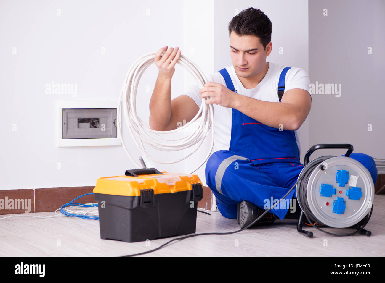 Young electrician working on socket at home Stock Photo - Alamy