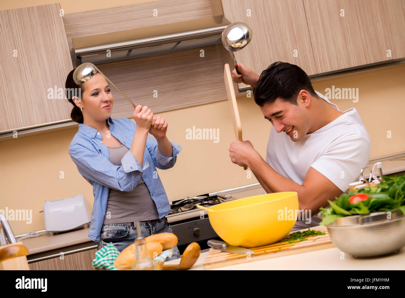 The young family doing funny fight at kitchen Stock Photo - Alamy