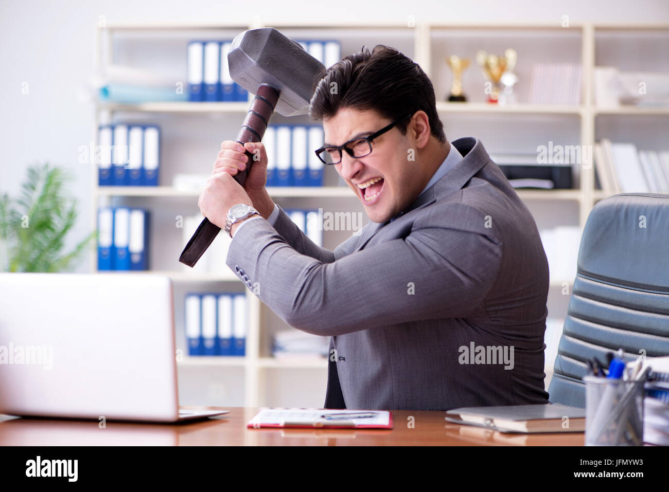Aggressive man breaking laptop hammer hi-res stock photography and ...