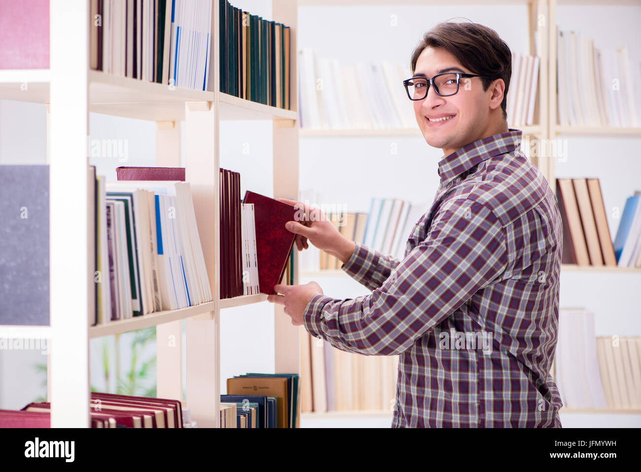 The young student looking for books in college library Stock Photo - Alamy