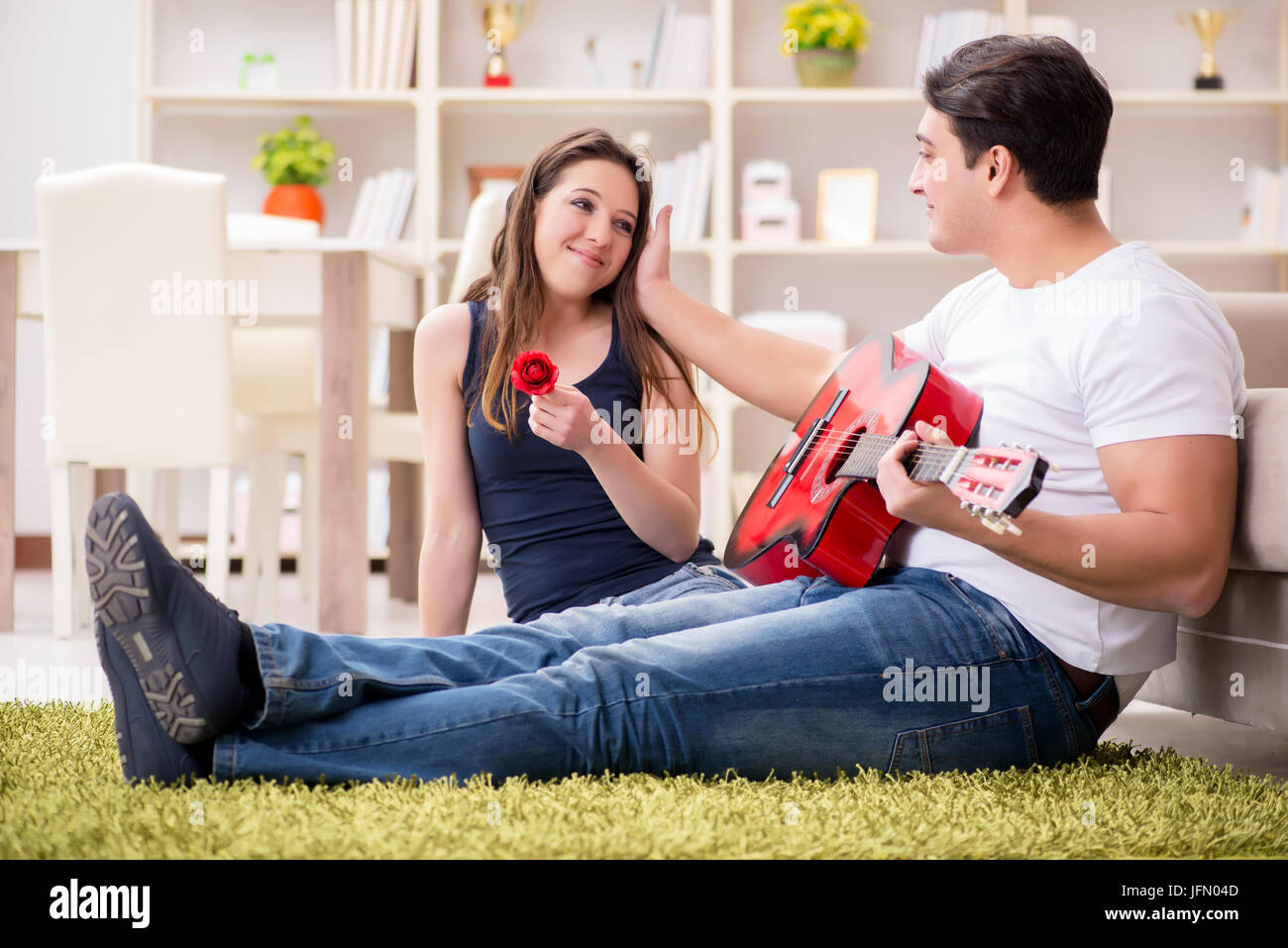 The romantic pair playing guitar on floor Stock Photo - Alamy