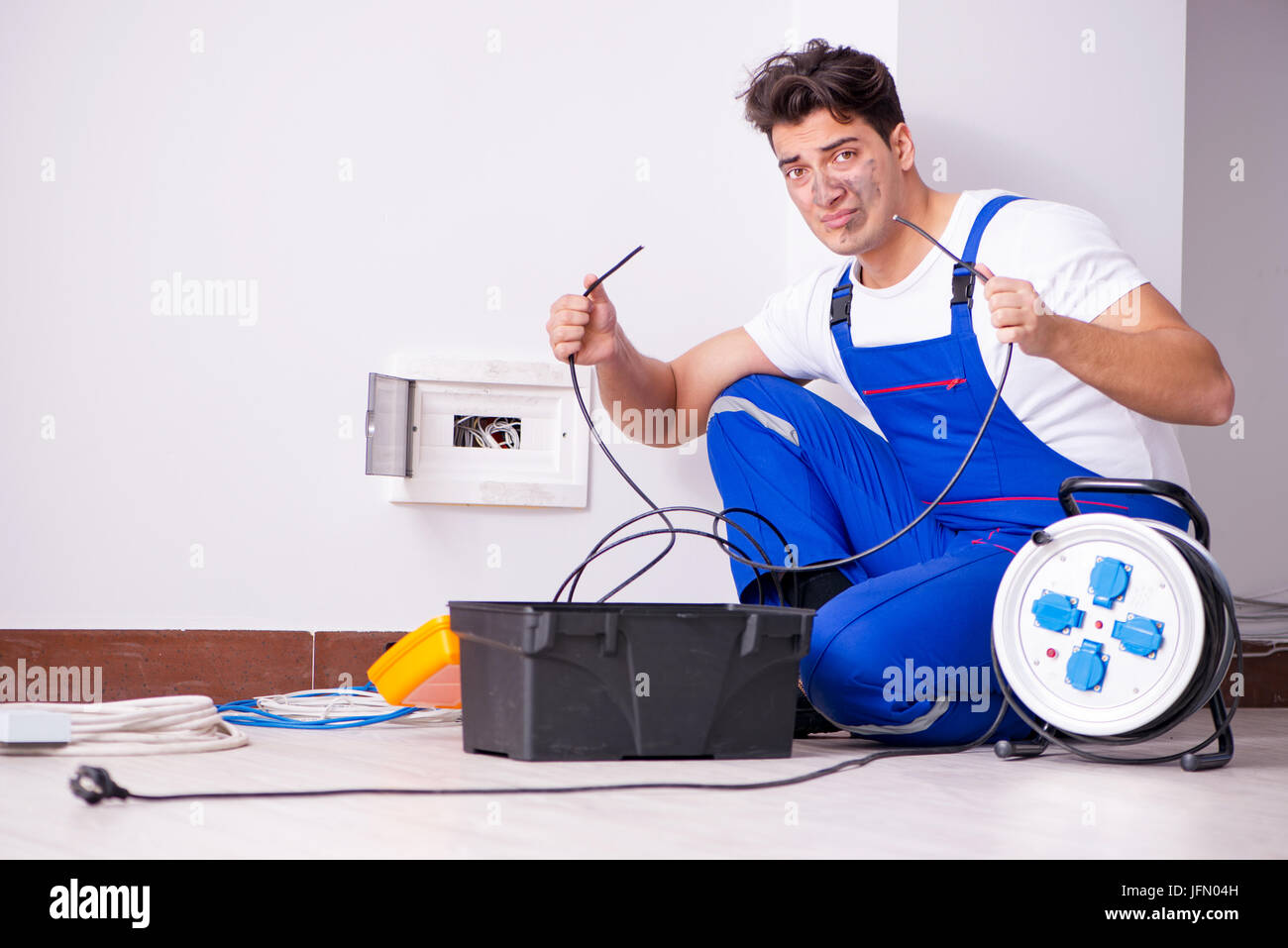 The funny man doing electrical repairs at home Stock Photo - Alamy