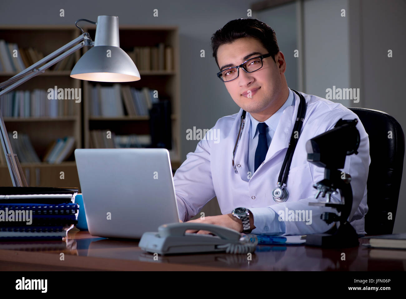 The young doctor working late in the office Stock Photo - Alamy