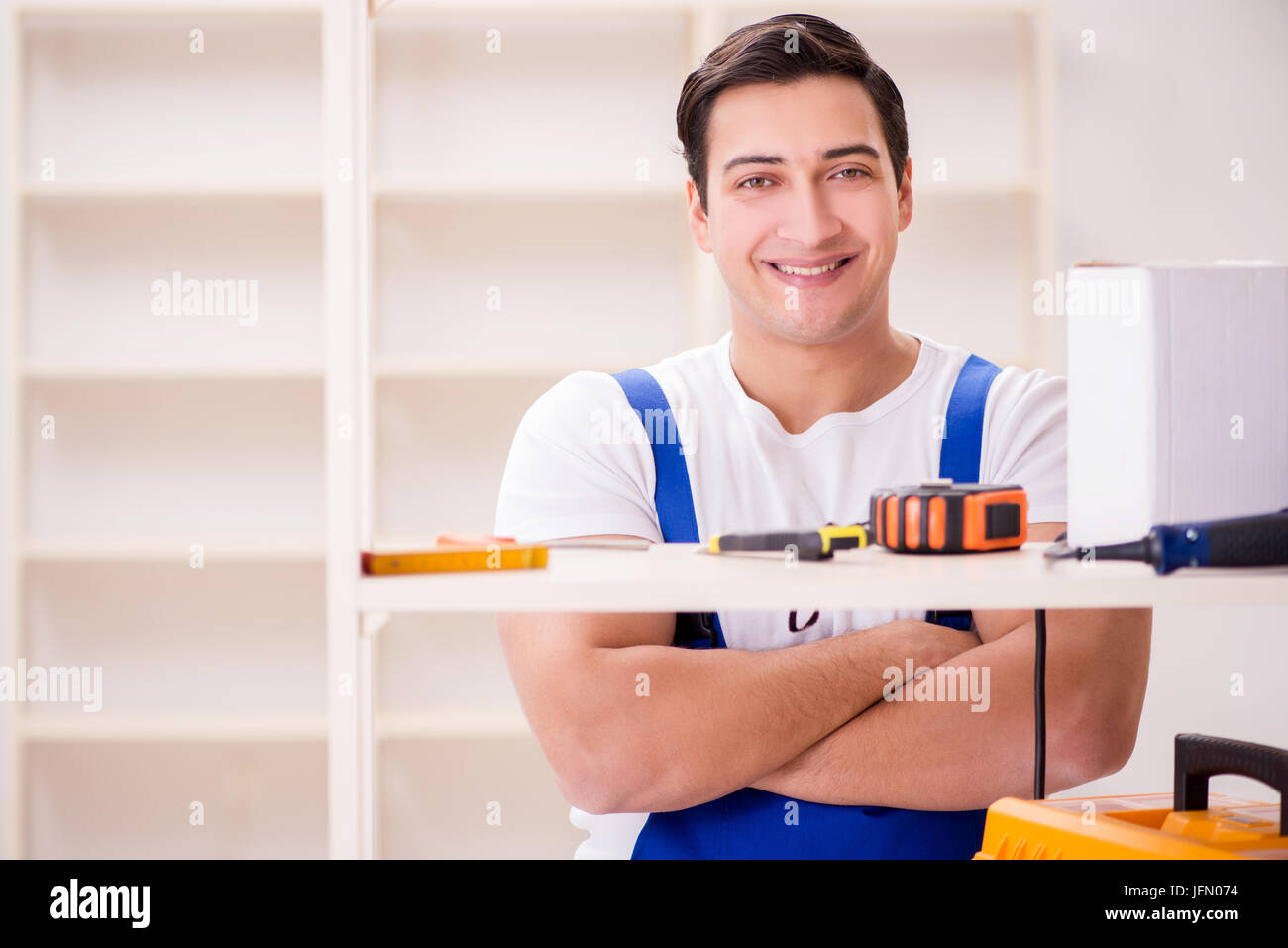 The worker man repairing assembling bookshelf Stock Photo - Alamy