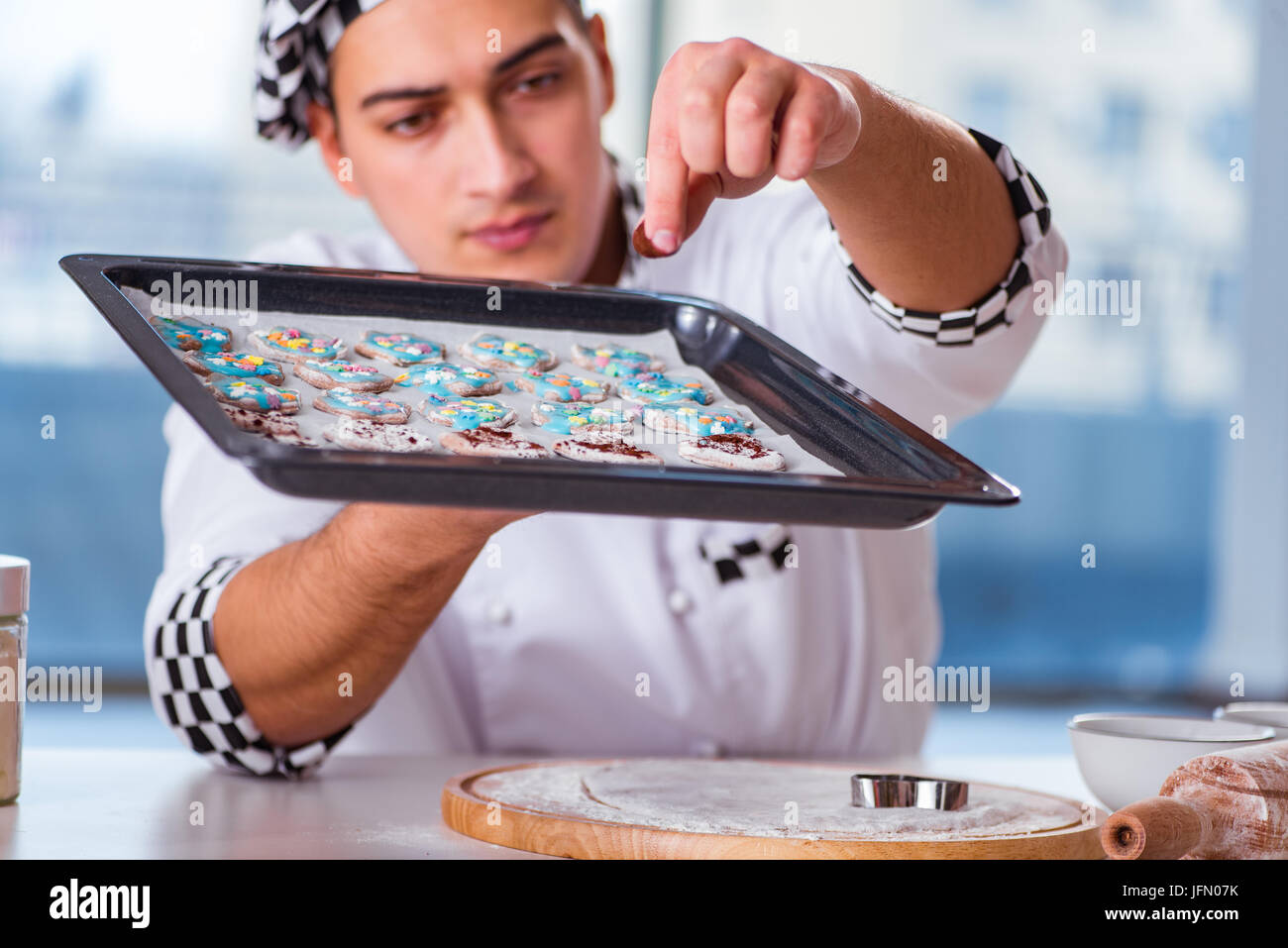 The young man cooking cookies in kitchen Stock Photo - Alamy