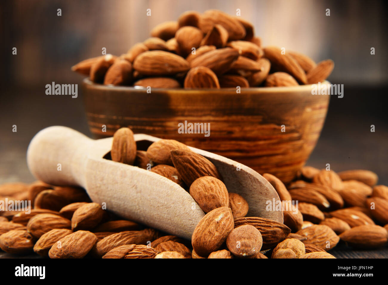 Bowl with shelled almonds on wooden table. Delicacies Stock Photo - Alamy