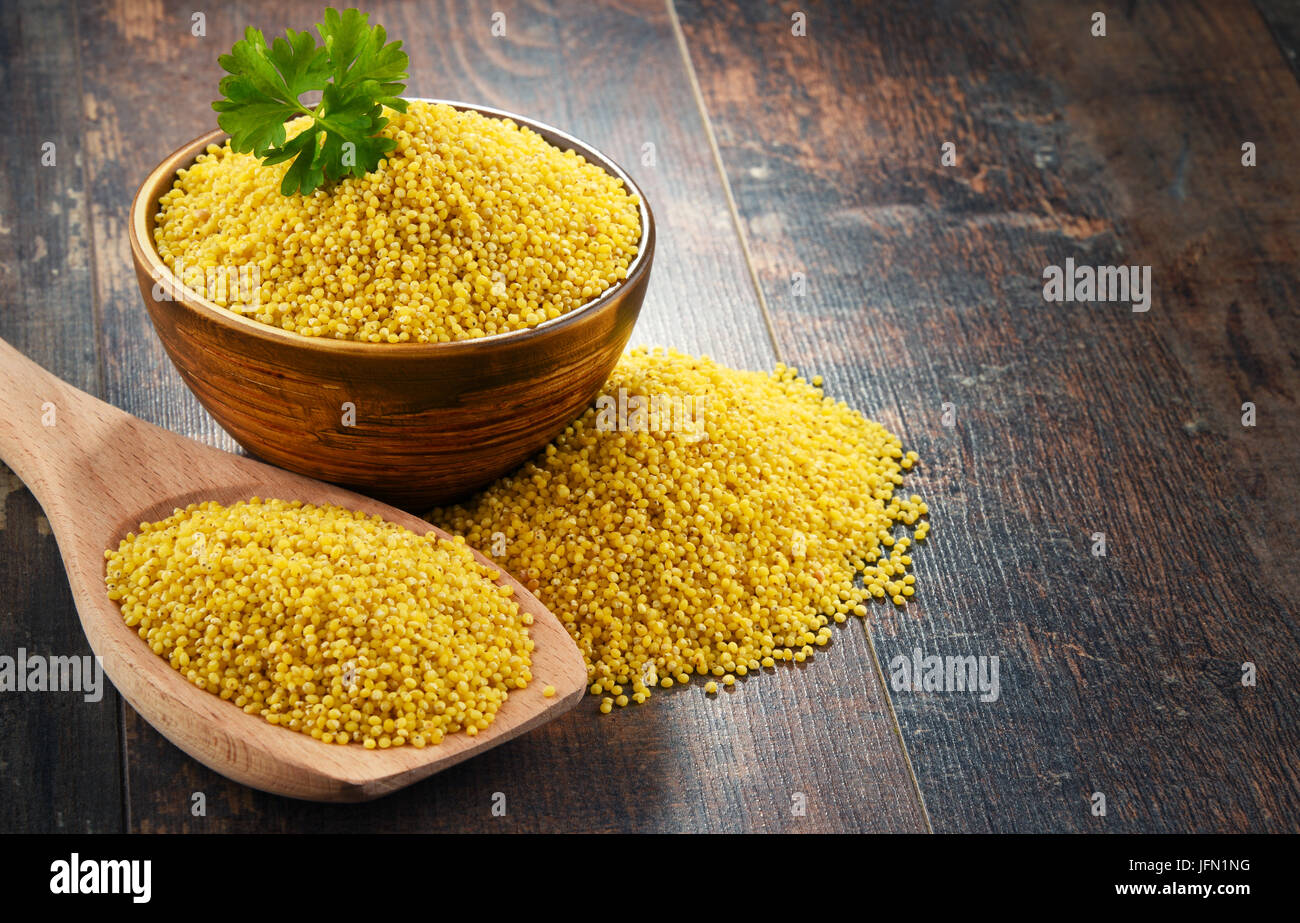 Composition with bowl of millet on wooden table Stock Photo - Alamy