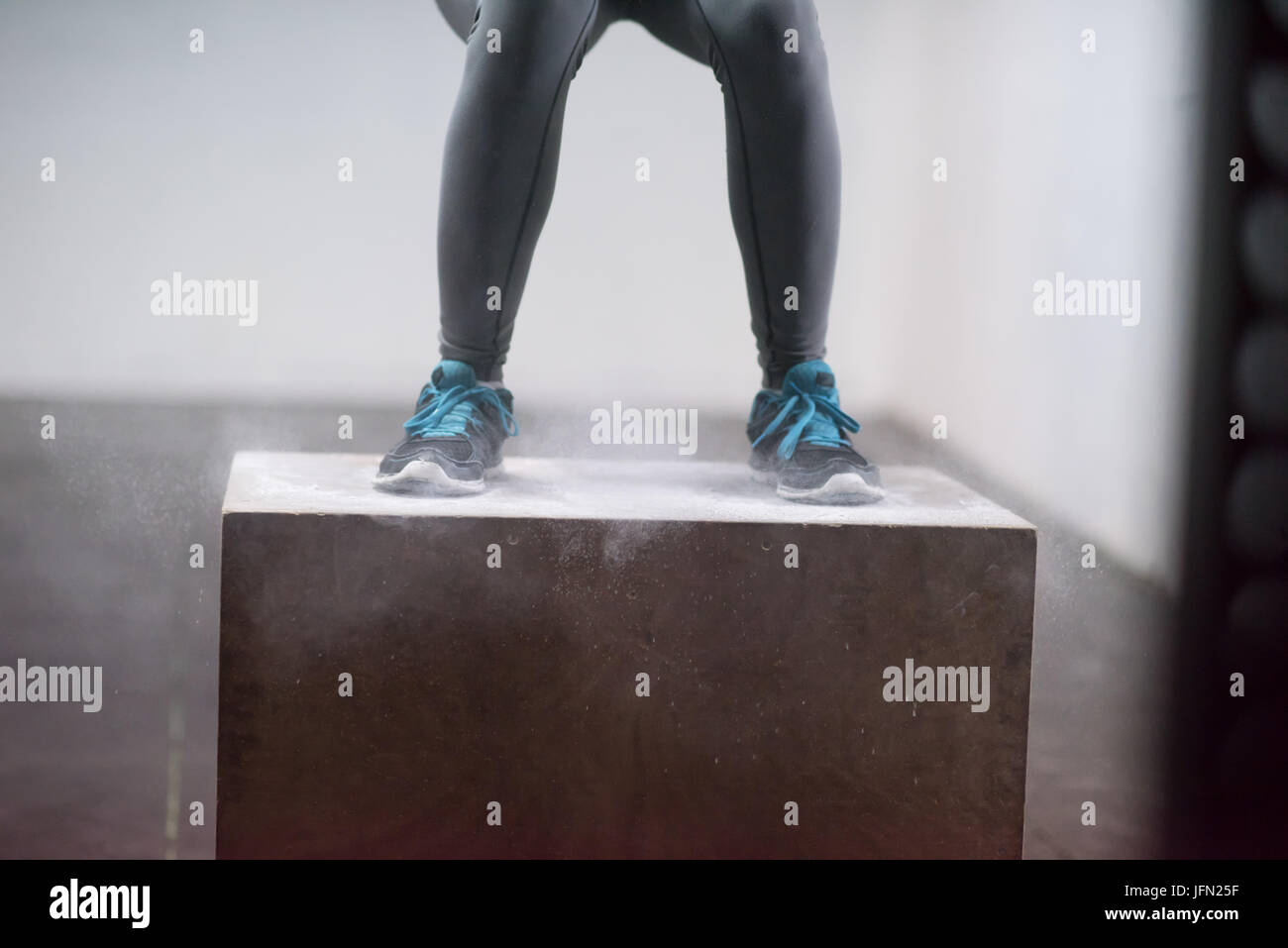 Fit young african american woman box jumping at a crossfit style gym ...