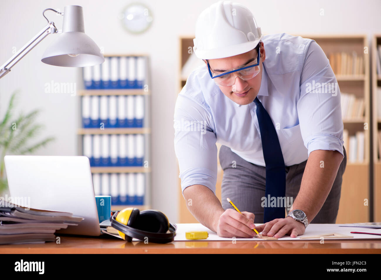 The engineer supervisor working on drawings in the office Stock Photo ...