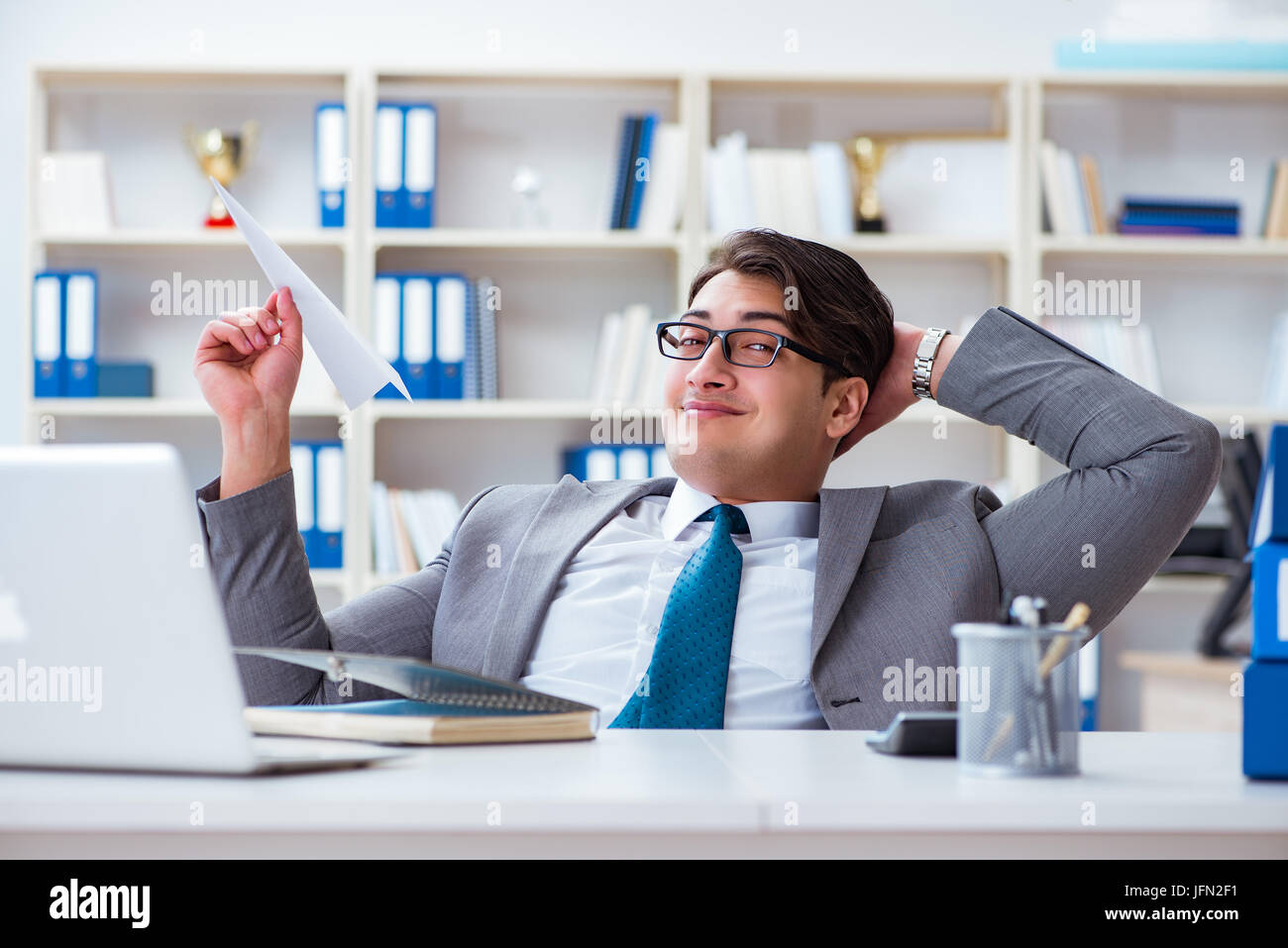 The businessman with paper airplane in office Stock Photo - Alamy