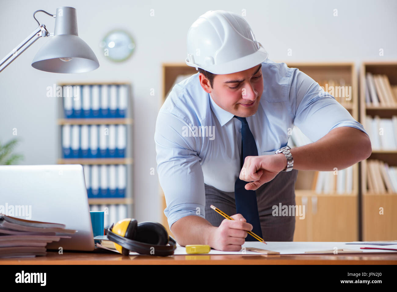 The engineer supervisor working on drawings in the office Stock Photo ...