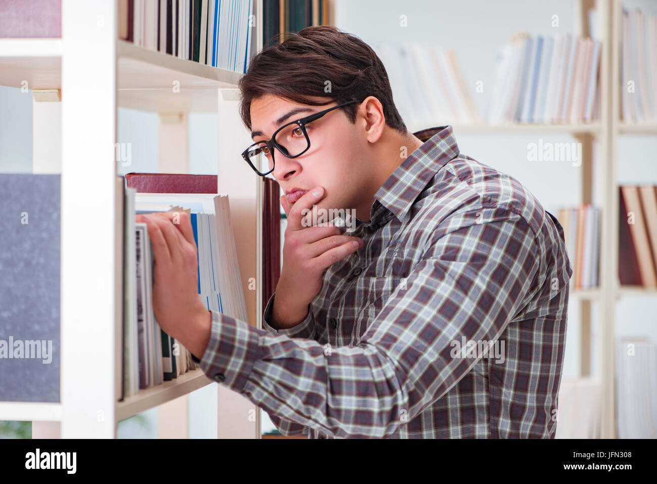 The young student looking for books in college library Stock Photo - Alamy