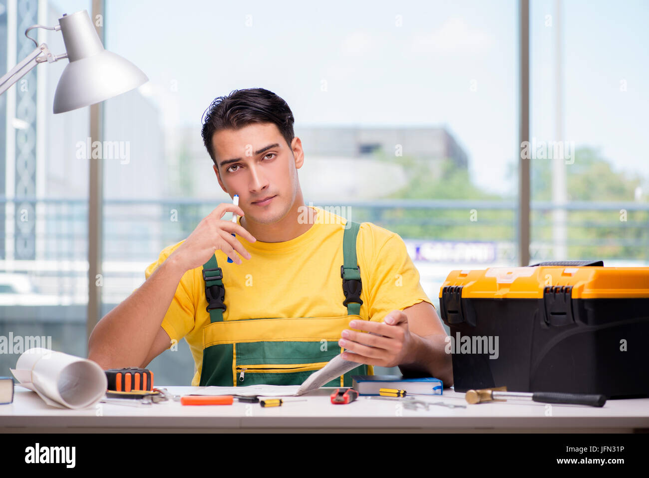 The construction worker sitting at the desk Stock Photo - Alamy