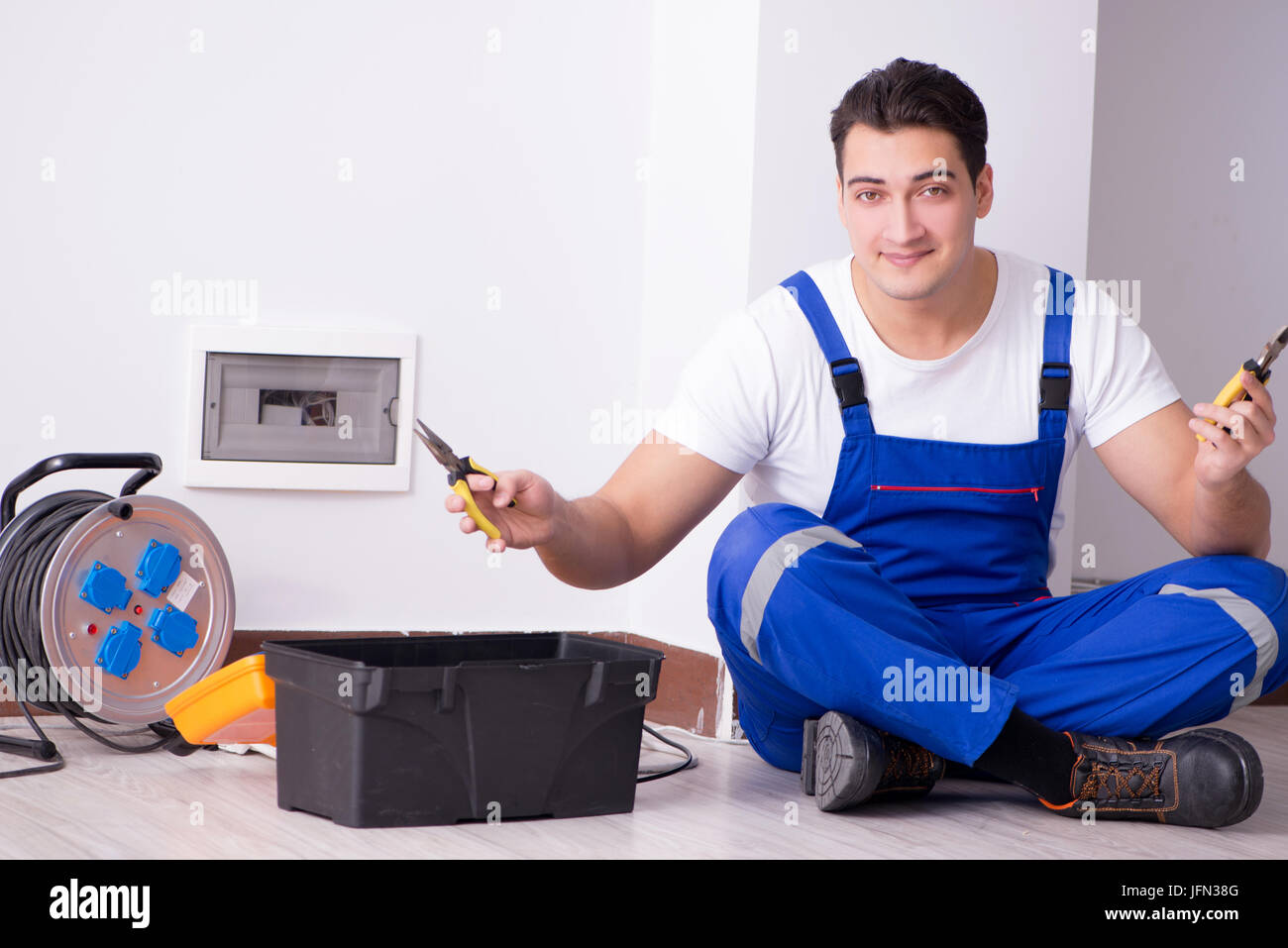 The young electrician working on socket at home Stock Photo - Alamy