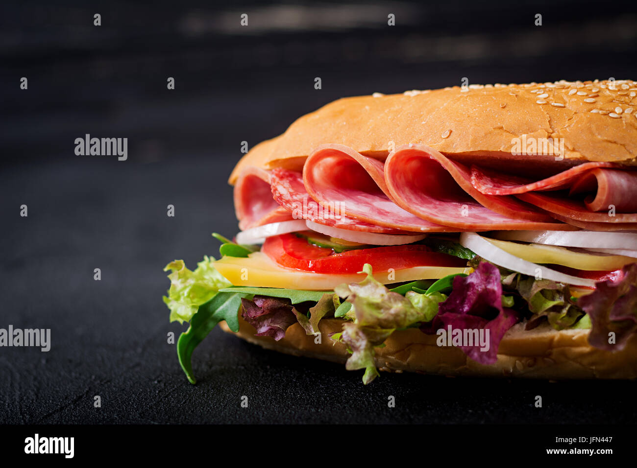 Big sandwich with ham, salami, tomato, cucumber and herbs Stock Photo ...