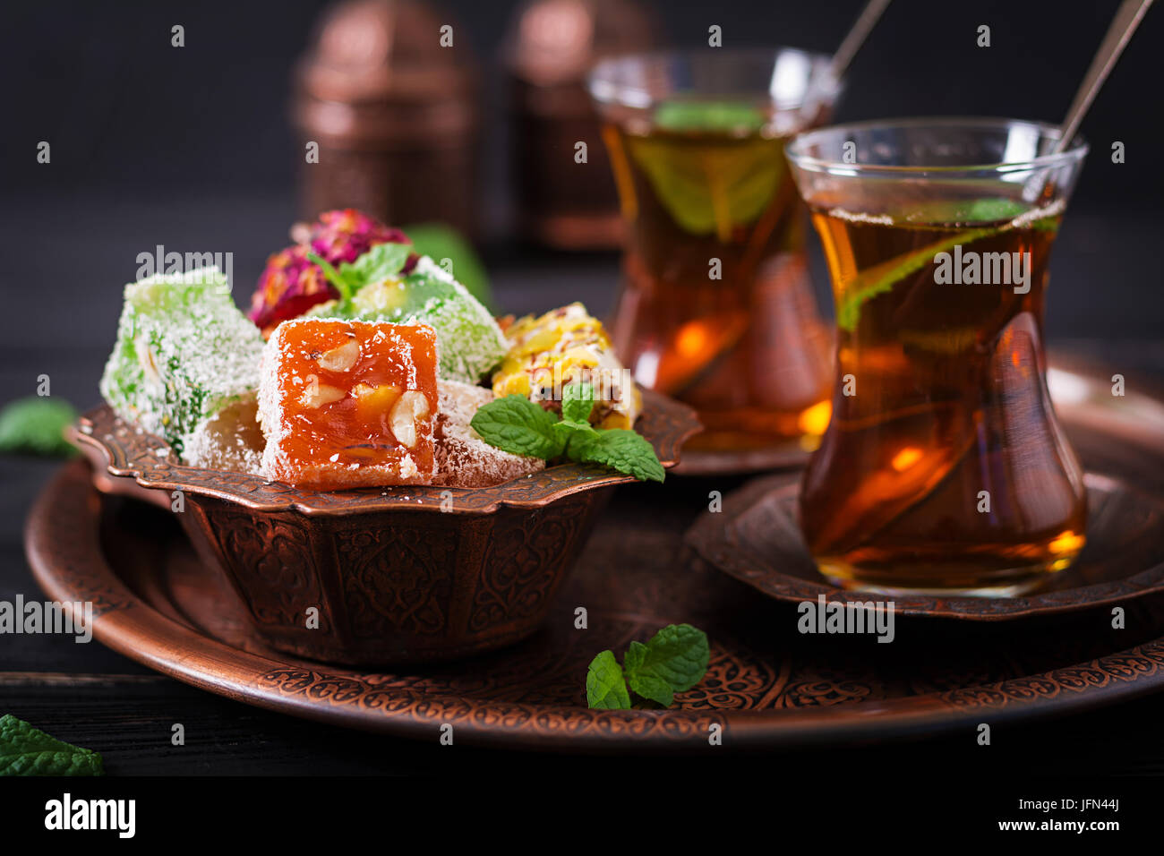 Bowl with various pieces of turkish delight lokum and black tea with ...
