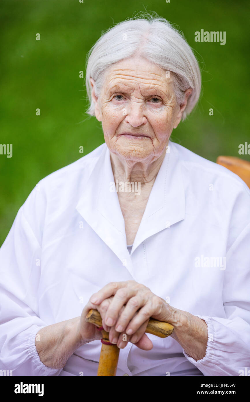 Senior woman sitting on bench in summer park Stock Photo - Alamy