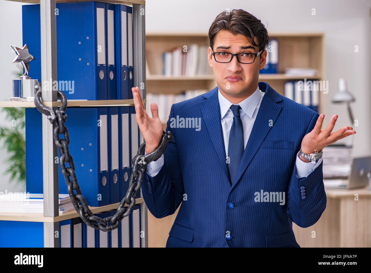 Young man standing next to the shelf with folders Stock Photo - Alamy