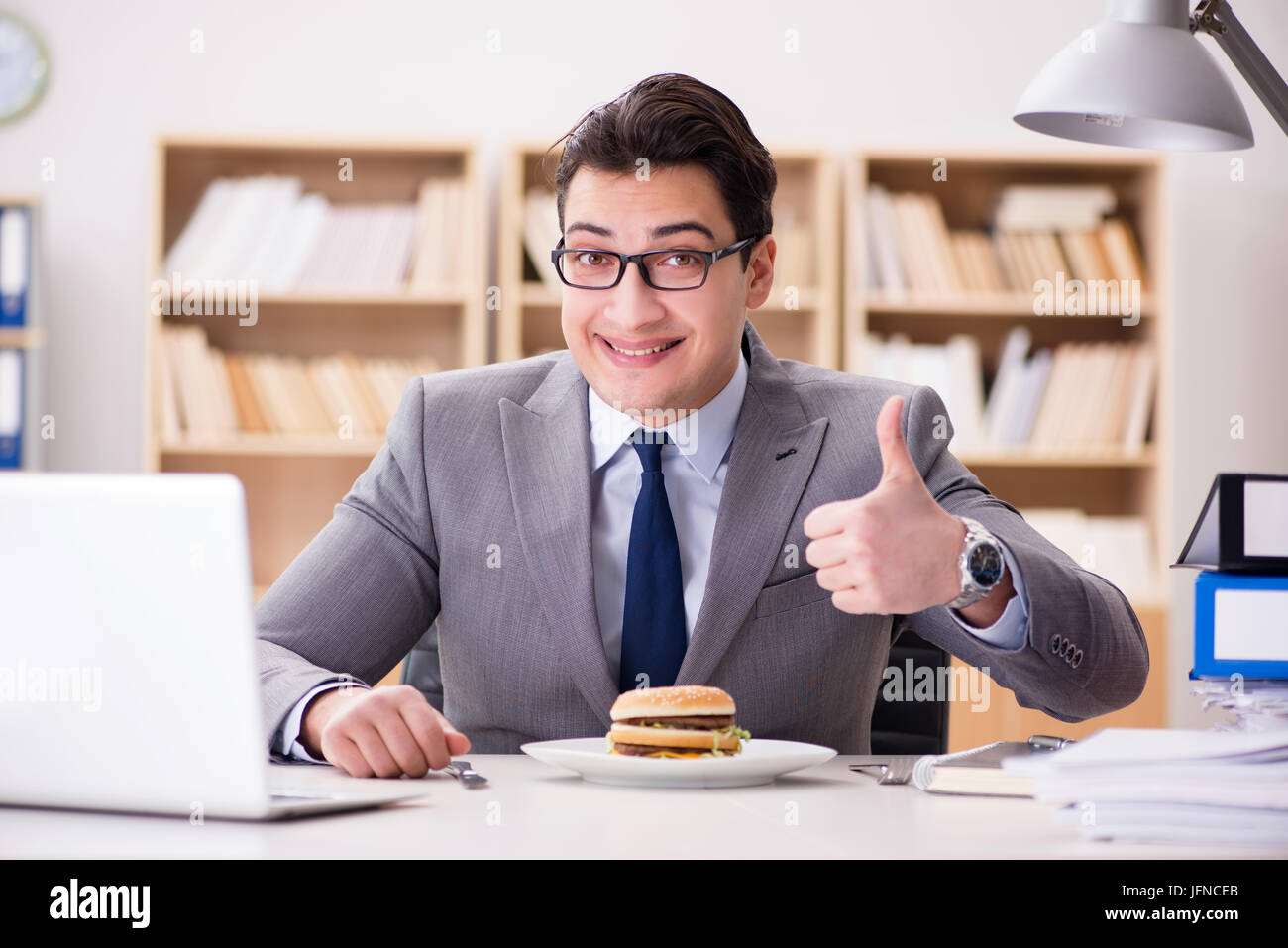Hungry funny businessman eating junk food sandwich Stock Photo - Alamy