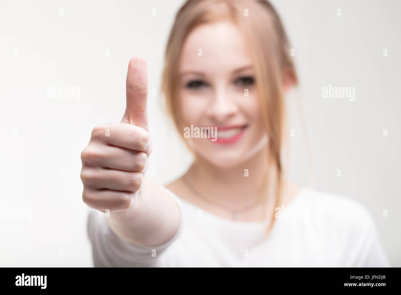 Pretty young woman giving a thumbs up sign of approval, success and ...