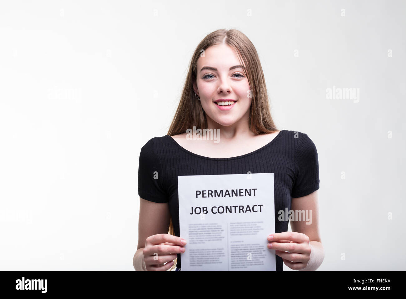 Smiling successful happy young job applicant holding up a Permanent Job ...