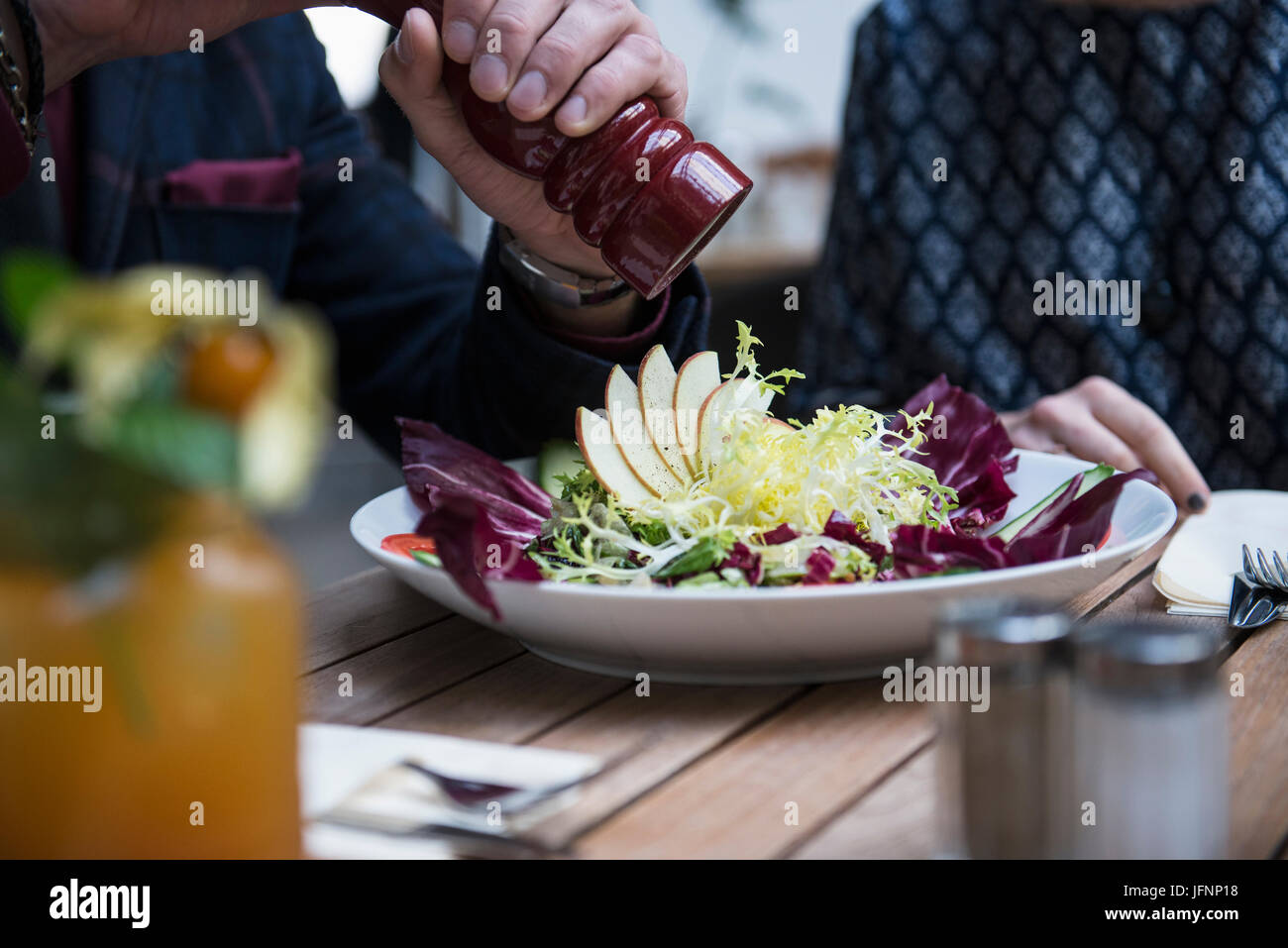 Midsection of man seasoning salad with pepper Stock Photo - Alamy
