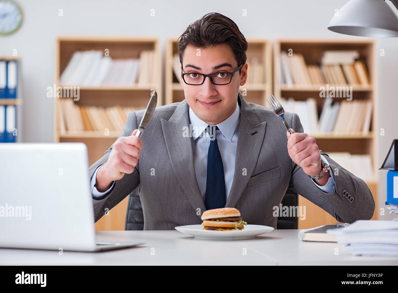 Hungry funny businessman eating junk food sandwich Stock Photo - Alamy