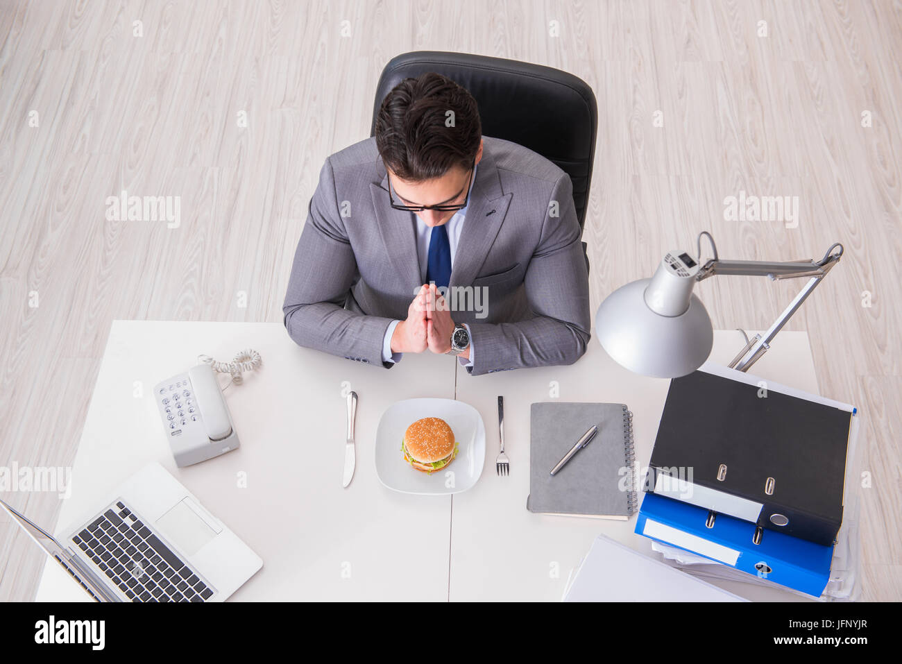 Hungry funny businessman eating junk food sandwich Stock Photo - Alamy
