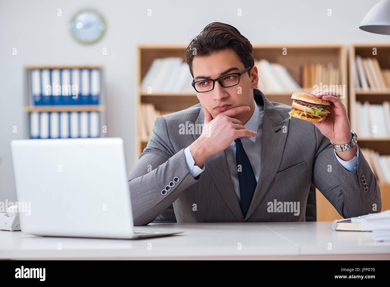 Hungry funny businessman eating junk food sandwich Stock Photo - Alamy