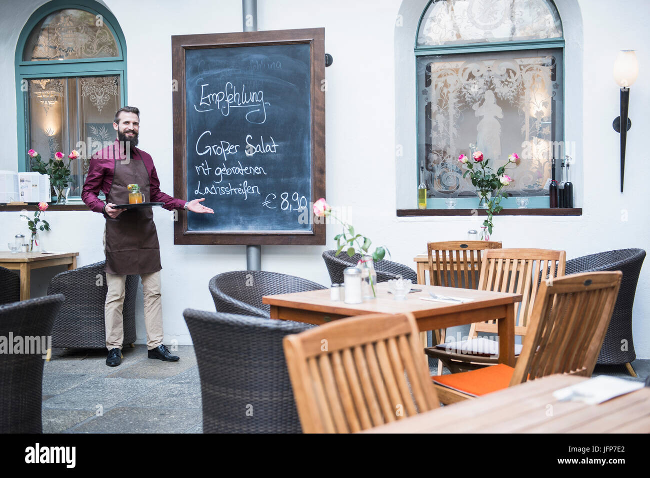 Young man pointing at chalkboard menu in restaurant Stock Photo - Alamy