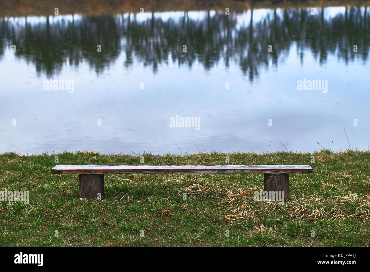 Lonely empty wooden bench by the lake Stock Photo - Alamy
