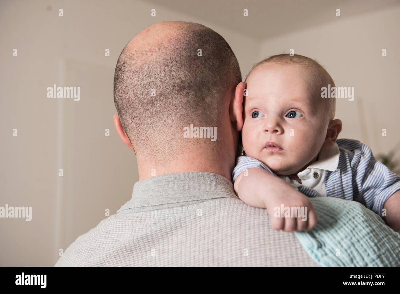 Baby boy peering over his father's shoulder Stock Photo - Alamy