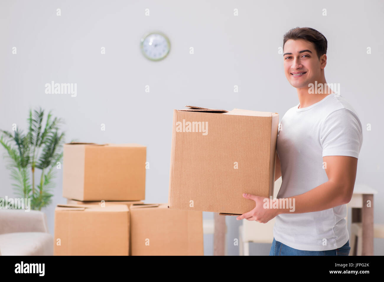Man carrying boxes at home Stock Photo - Alamy
