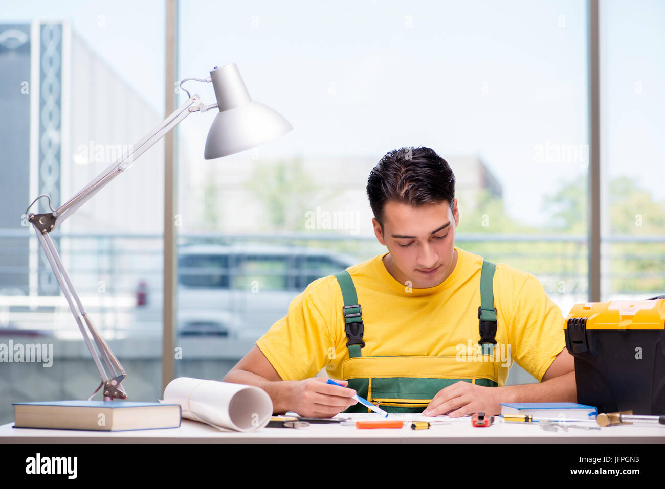 Construction worker sitting at the desk Stock Photo - Alamy
