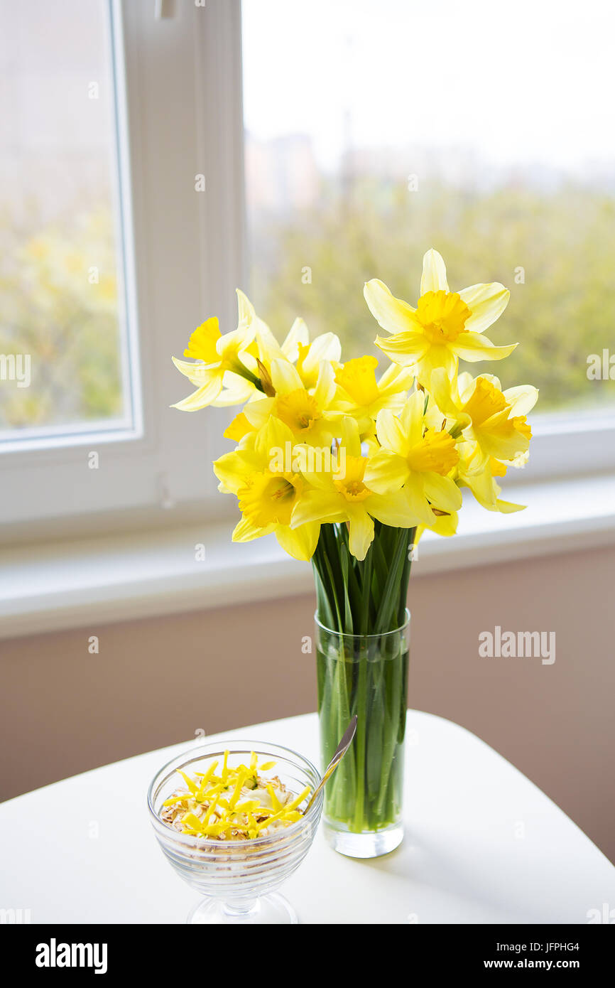 Posy of bright yellow daffodils on white wooden table Stock Photo - Alamy