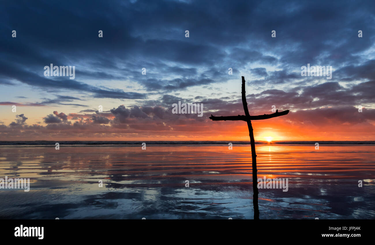 Cross on a beach at sunset with a reflection Stock Photo - Alamy