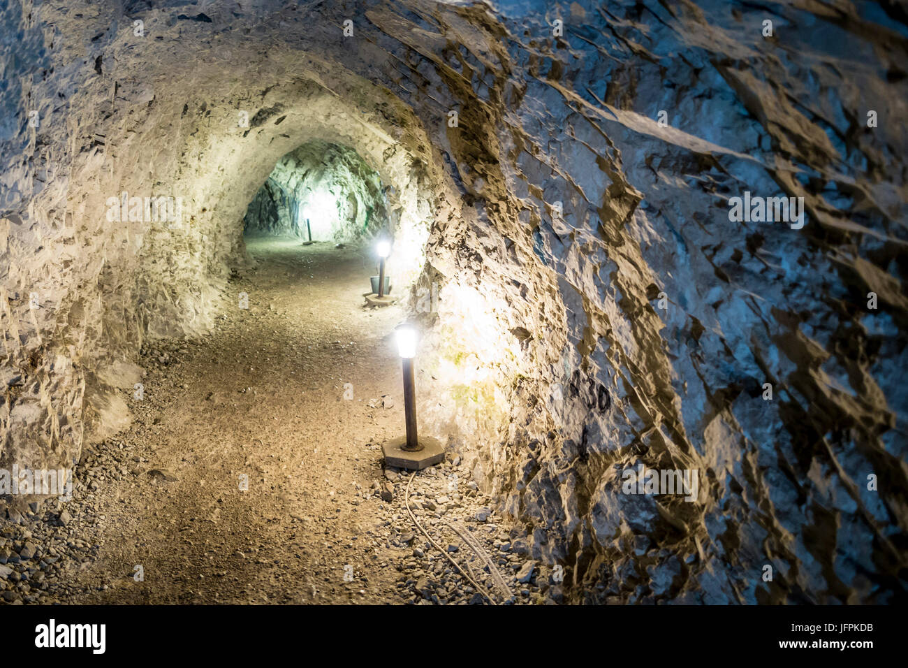 Mining tunnel in stone rock. Cave tunnel with lights. Underground mine ...