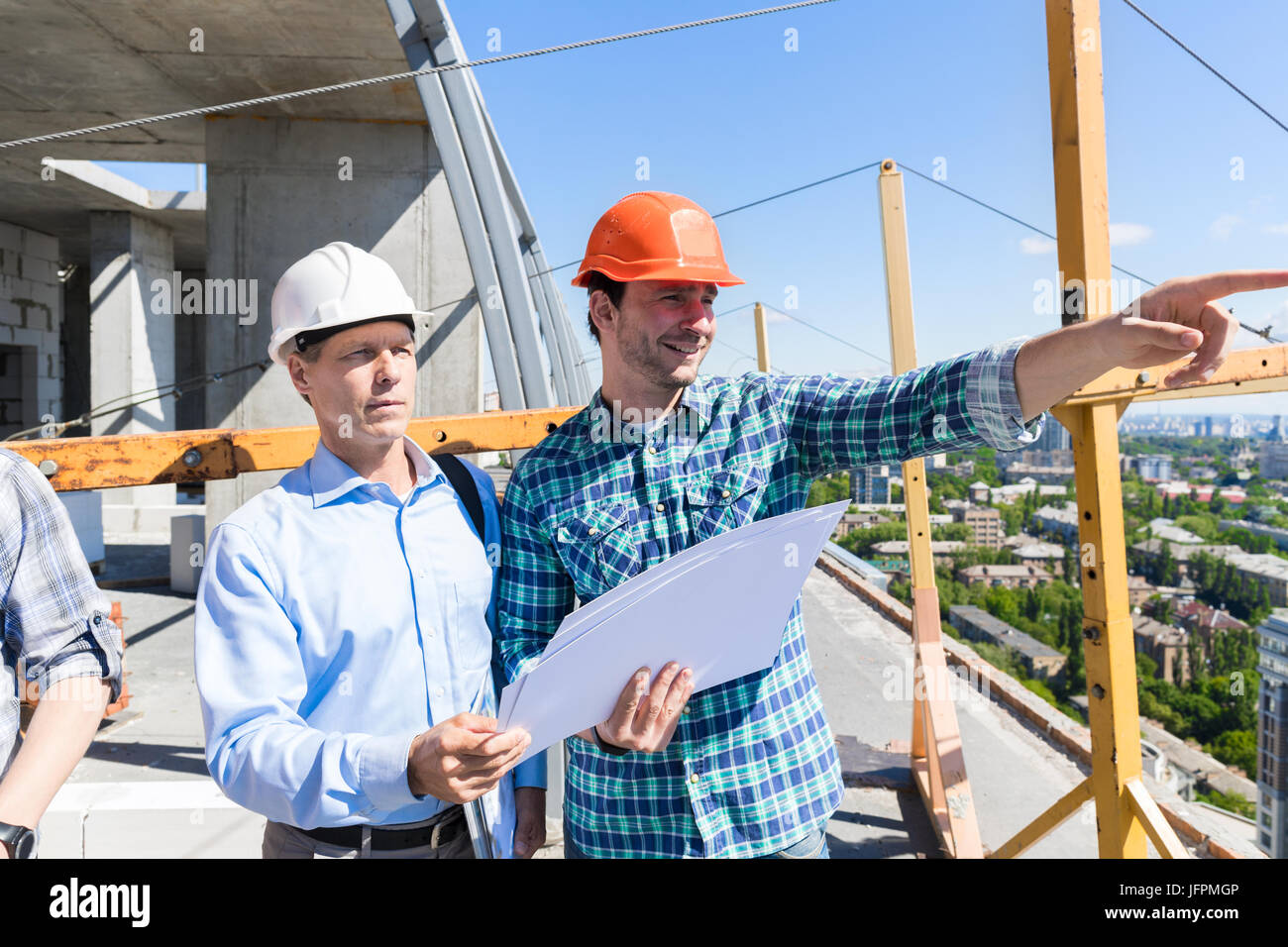 Two Builders On Construction Site Looking At Plans Contractor Meeting ...