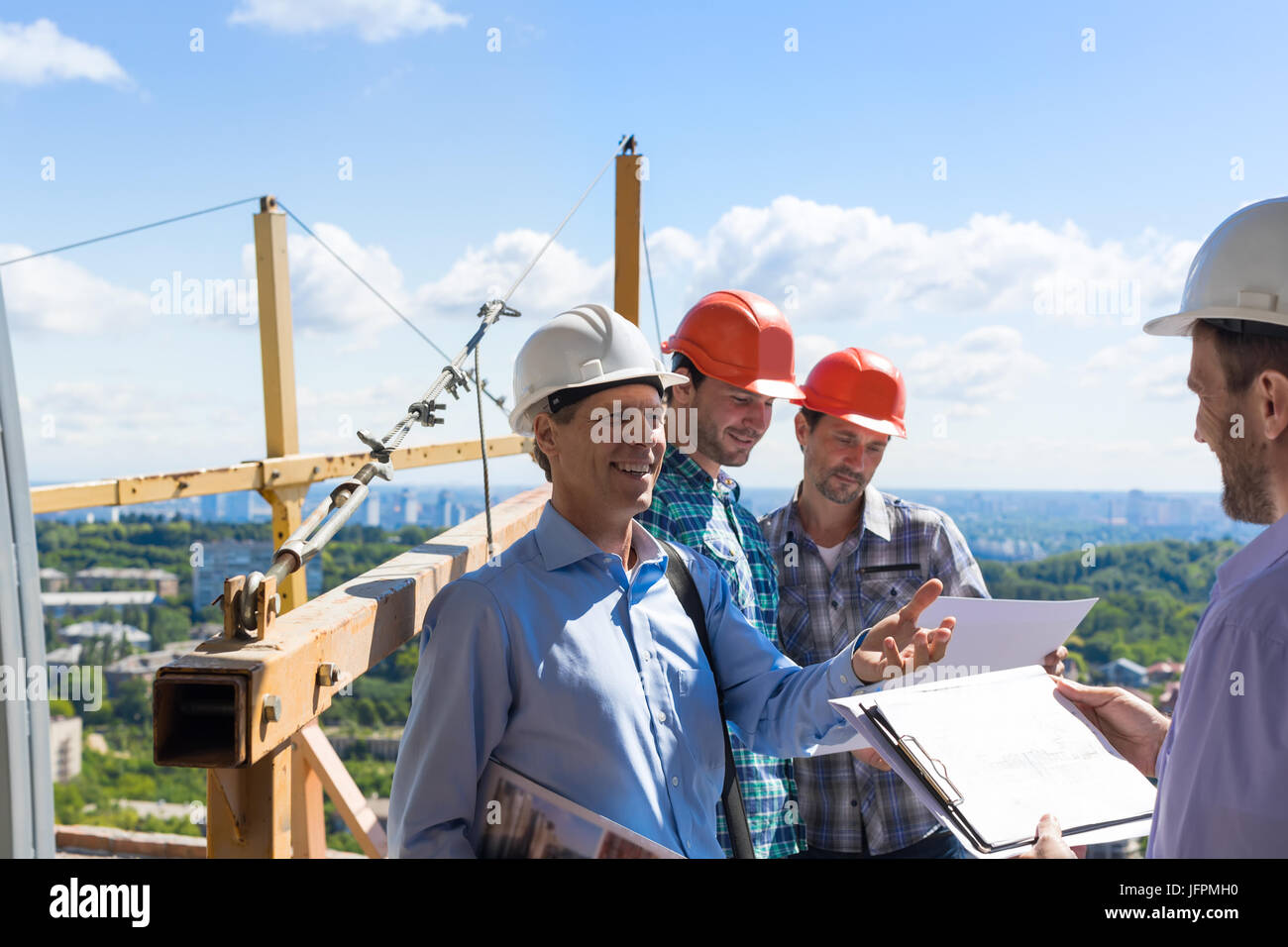 Builders Team Meeting With On Construction Site Discussing Project Plan ...