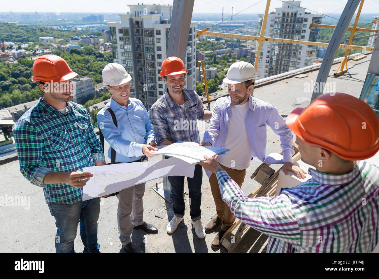 Builders On Site Looking On PLan Blueprint Contractor Explaining ...