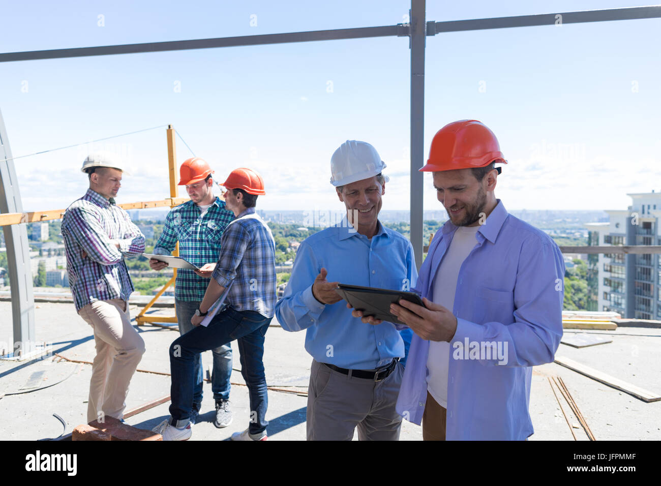 Builders On Site Holding Tablet Computer Discuss Construction Project ...