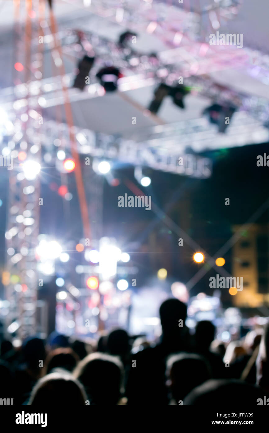 crowd at concert against a brightly lit stage. bright concert lighting ...